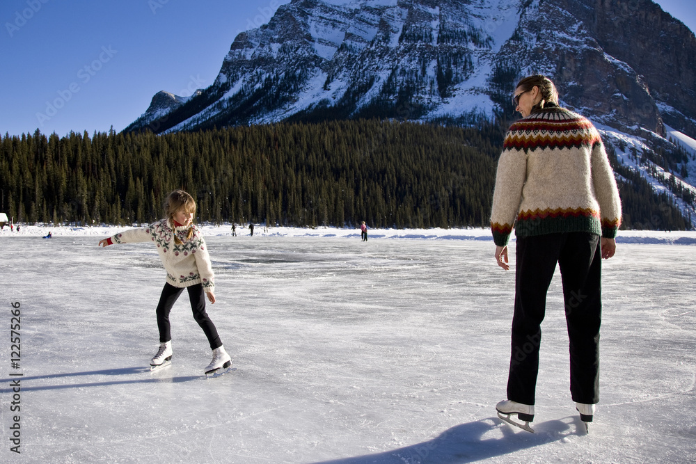 Foto Mother and daughter ice skating at Lake Louise, Banff National ...