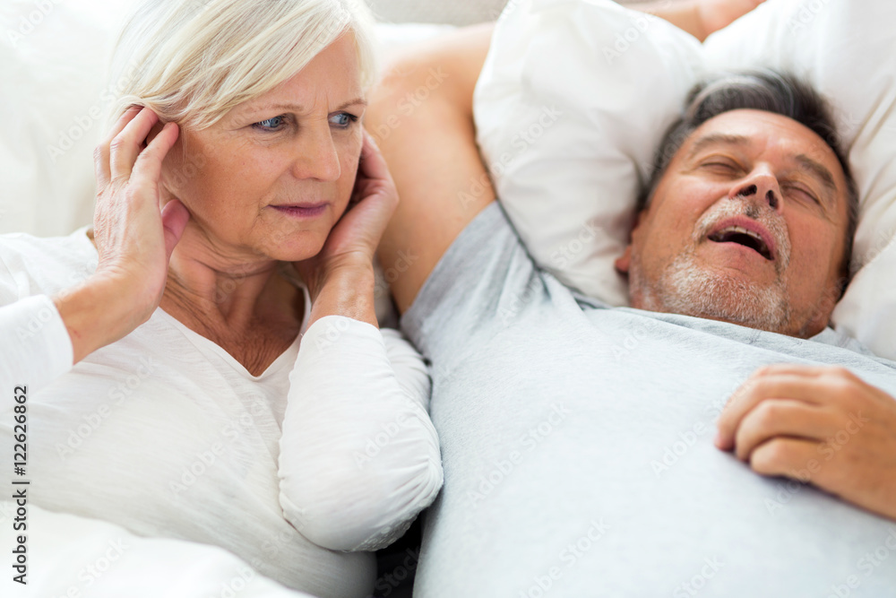 Foto Senior man snoring and woman covering ears do Stock | Adobe Stock