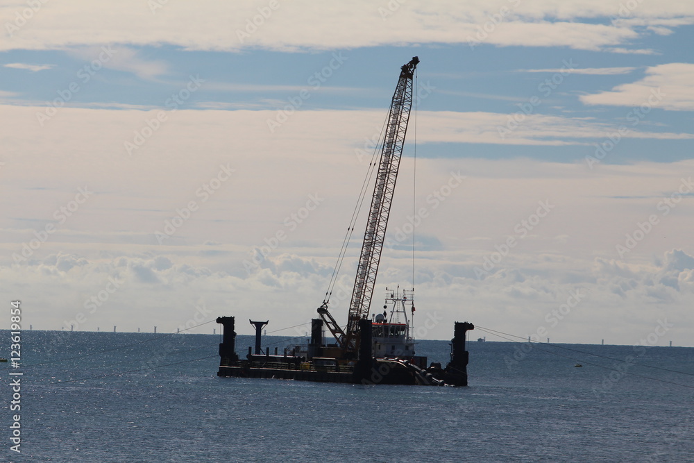 Cable laying rig with offshore wind turbine foundations rising out of ...