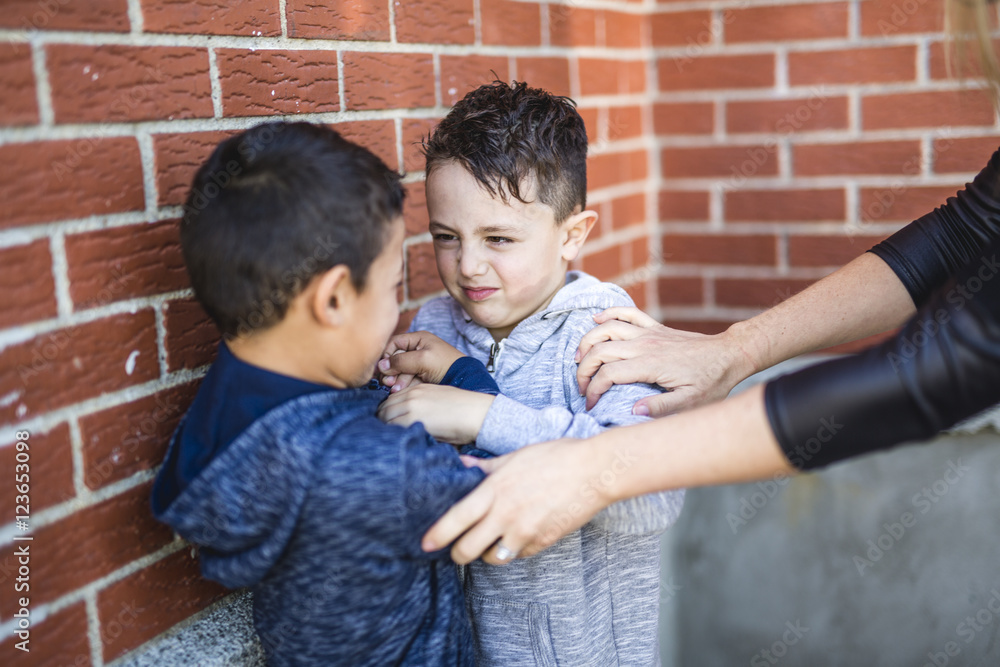 Teacher Stopping Two Boys Fighting In Playground Stock Photo | Adobe Stock