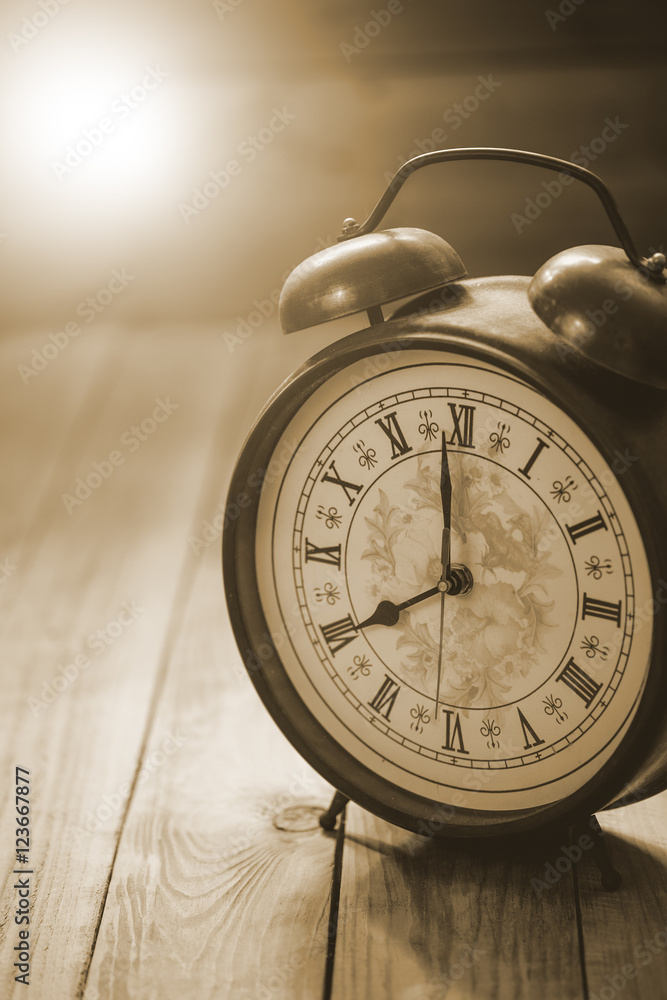 Retro watch with antique number is showing 8 o'clock on wooden ...