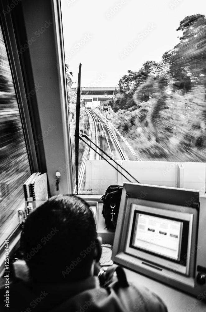 blurred image black and white of train driver behind the dashboard ...