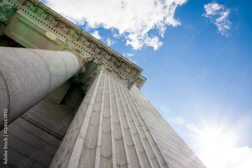 Upward view of a court house with impressive pillars. Morning sun ...