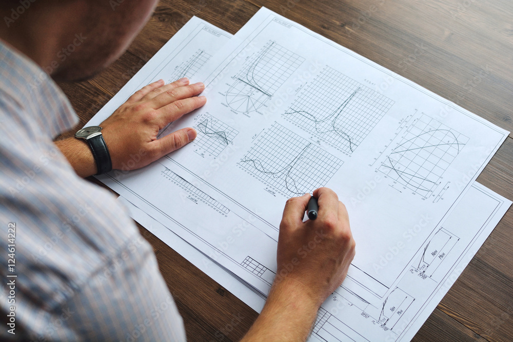 Mechanical engineer at work. Technical drawings. Paper with technical ...