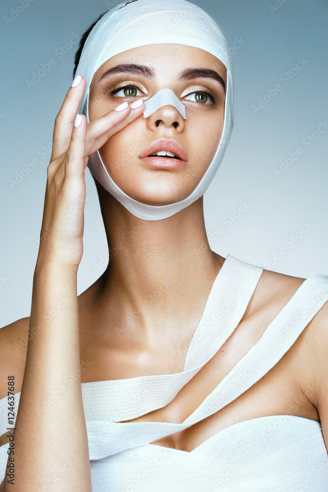 Woman removes the bandages from her head and touching her new face ...