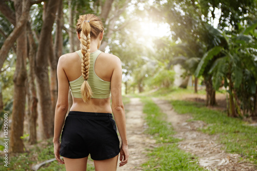 Confident And Successful Young Blonde Female Runner In Black Running Shorts Exercising Outdoors
