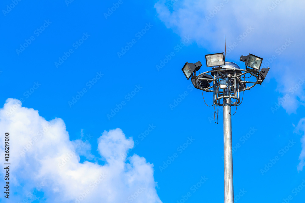 Spotlight and the sky clouds. Large tall high outdoor stadium ...