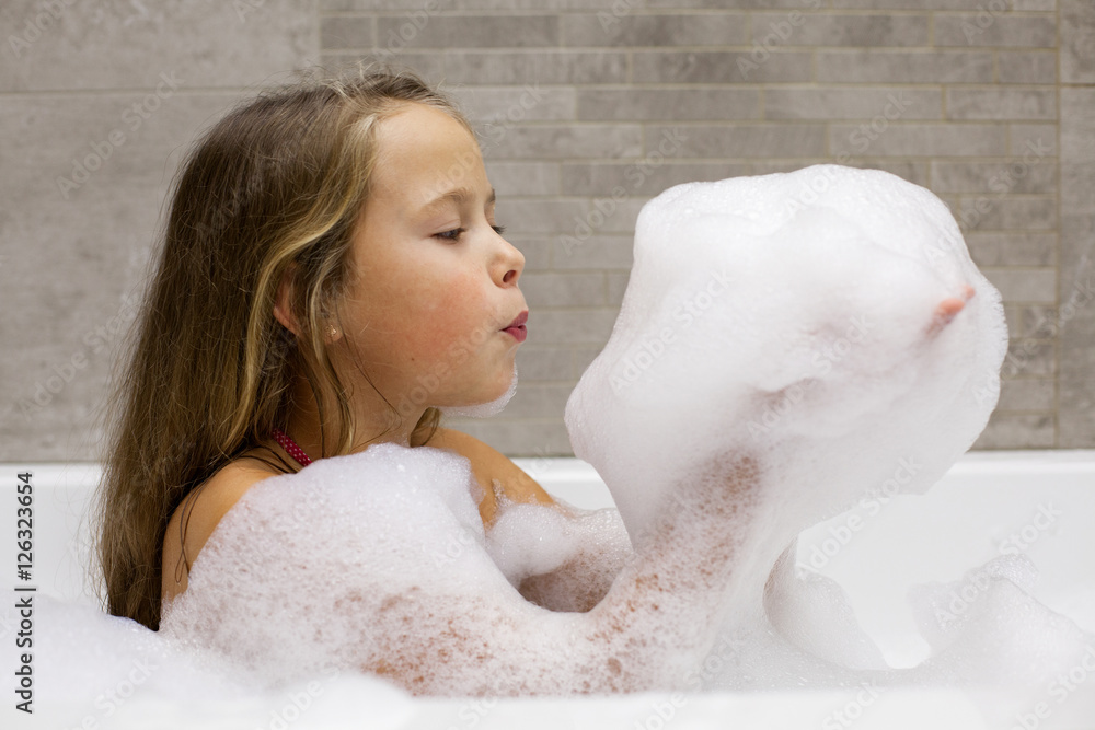 Cute little girl playing with foam in a bathroom Stock Photo | Adobe Stock