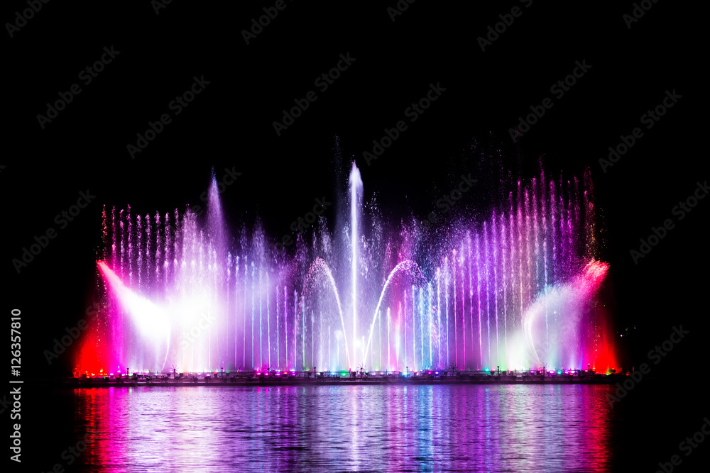 Beautiful fountain dancing show with reflection on water at night ...