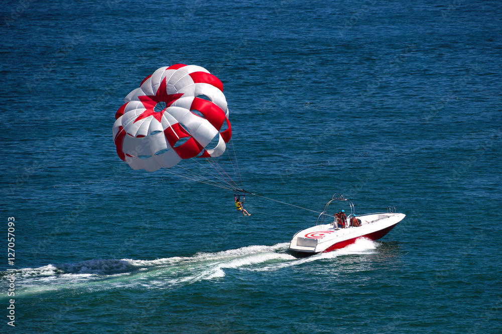 Parashuting water amusement. Flying on a parachute behind a boat on a ...
