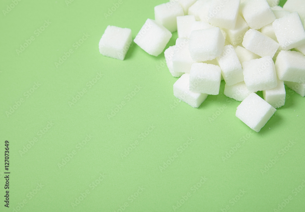 White sugar cubes arranged on a pastel green background with blank ...