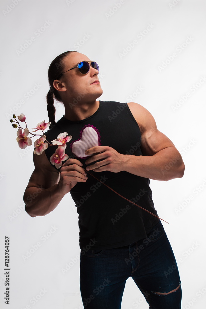 Portrait of a brutal man bodybuilder athlete in sunglasses with a sprig ...