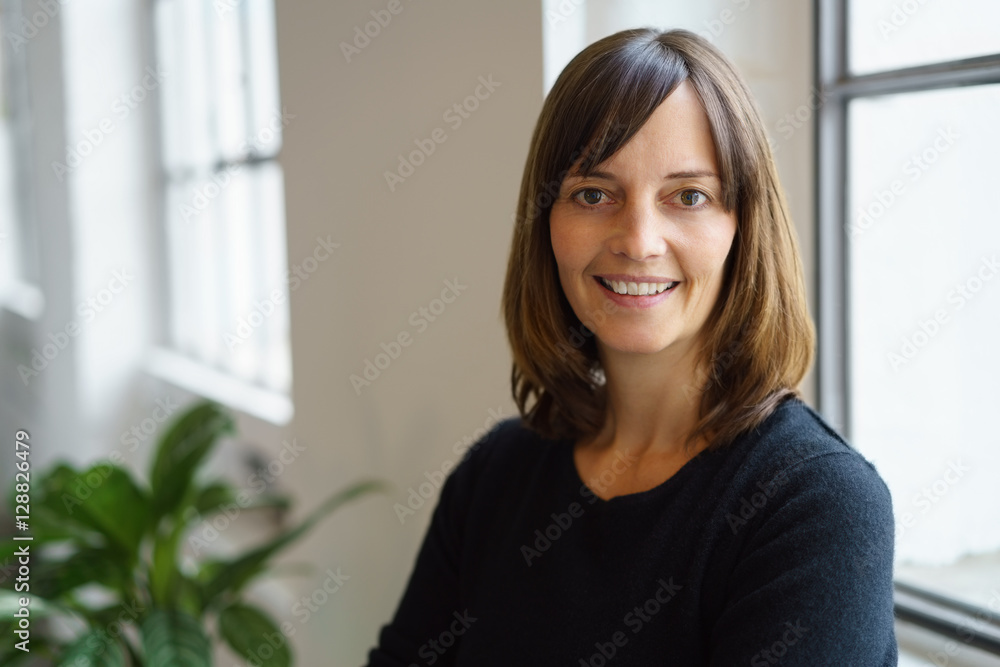 Stock-Foto „lächelnde frau steht zuhause am fenster“ | Adobe Stock