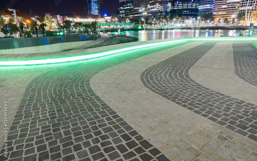 Green neon lights circulating underneath the stone seating reflecting ...