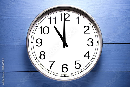 Round clock shows shows at 11 o'clock, clock on blue background Stock ...
