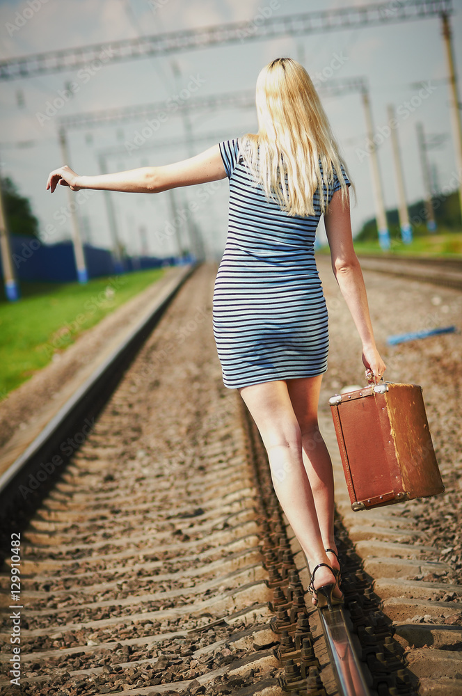 beautiful girl with a suitcase walking on railroad tracks Stock Photo ...