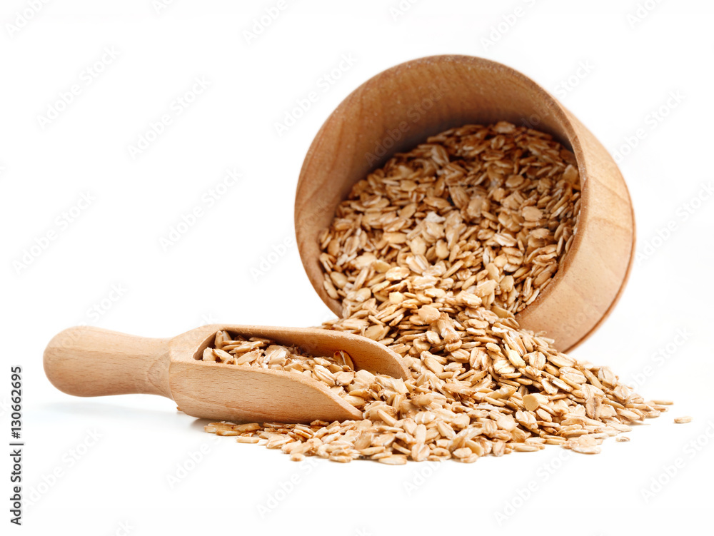 Oats scattered from wooden bowl on white background. Healthy food. Copy ...
