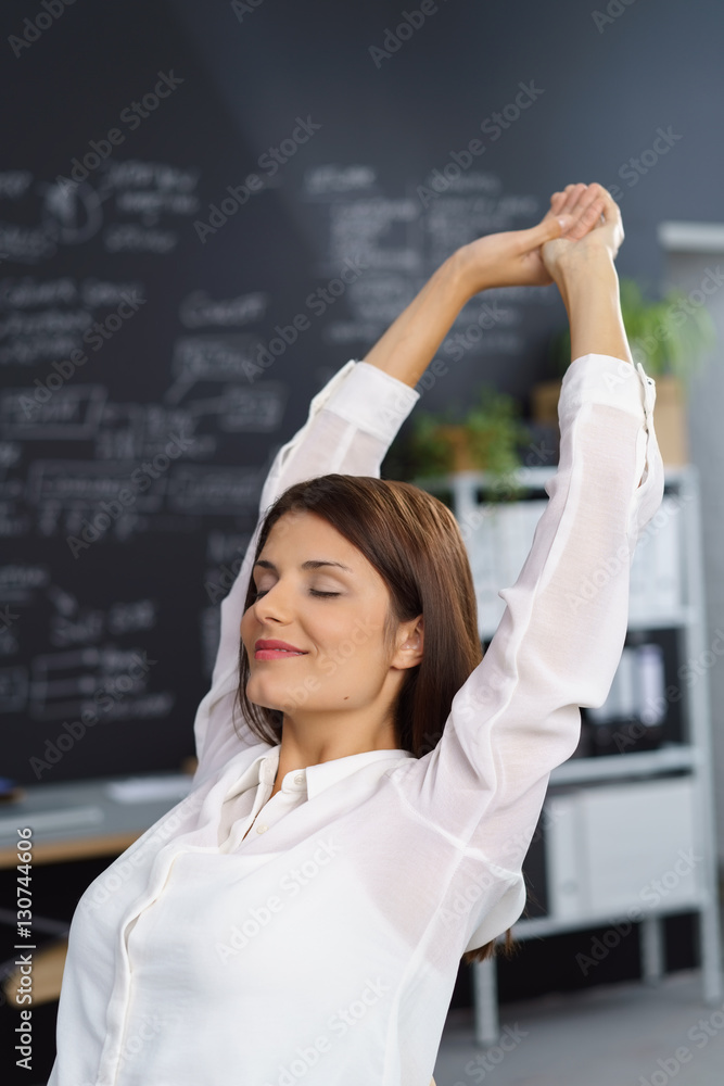 zufriedene frau am arbeitsplatz streckt die arme nach oben Stock Photo ...