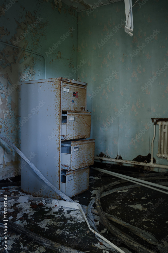 An old abandoned rusty filing cabinet in a decaying forgotten building ...