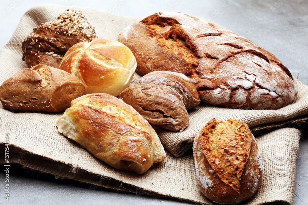 Different kinds of bread rolls on black board from above. Kitchen or ...