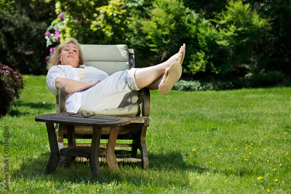 Mature woman relaxing with her feet up in a sunny Spring garden Stock ...