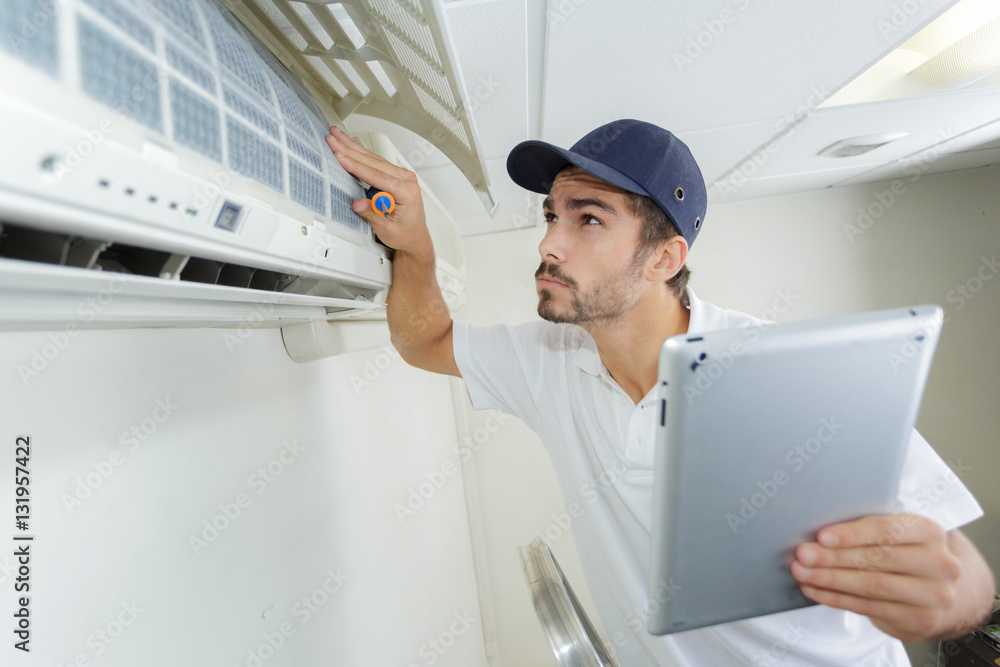 young contractor working carefully and seriously at clients office ...