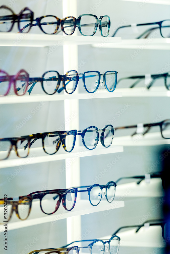 POV of customer looking at multiple eyeglasses frames in optical store ...