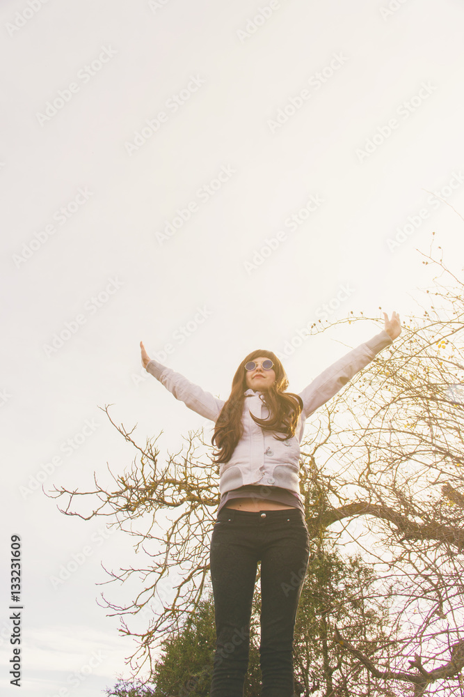 Mujer joven y feliz con sus brazos hacia el cielo y la luz del ...