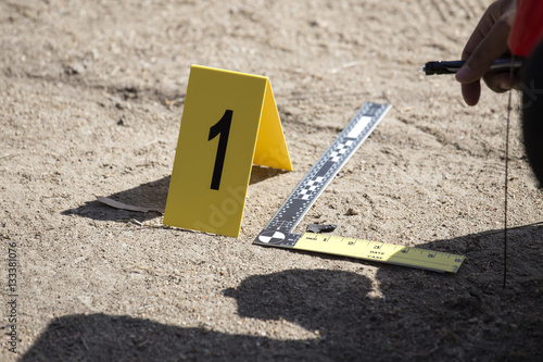 evidence marker and ruler scale of evidence with law enforcement hand ...