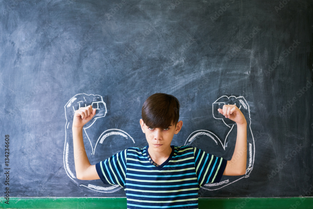 Strong Male Child Showing Muscles In Classroom At Lesson Stock Photo ...