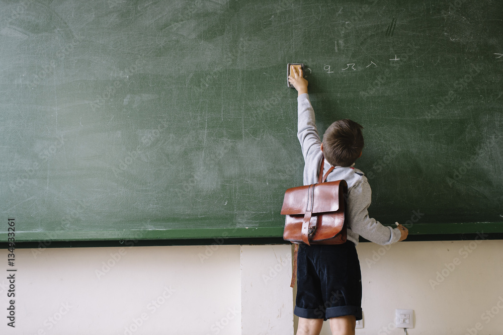 A kid cleaning the blackboard Stock Photo | Adobe Stock