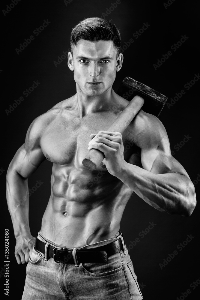 Muscular man with naked torso holding big hummer. Isolated on dark grey ...