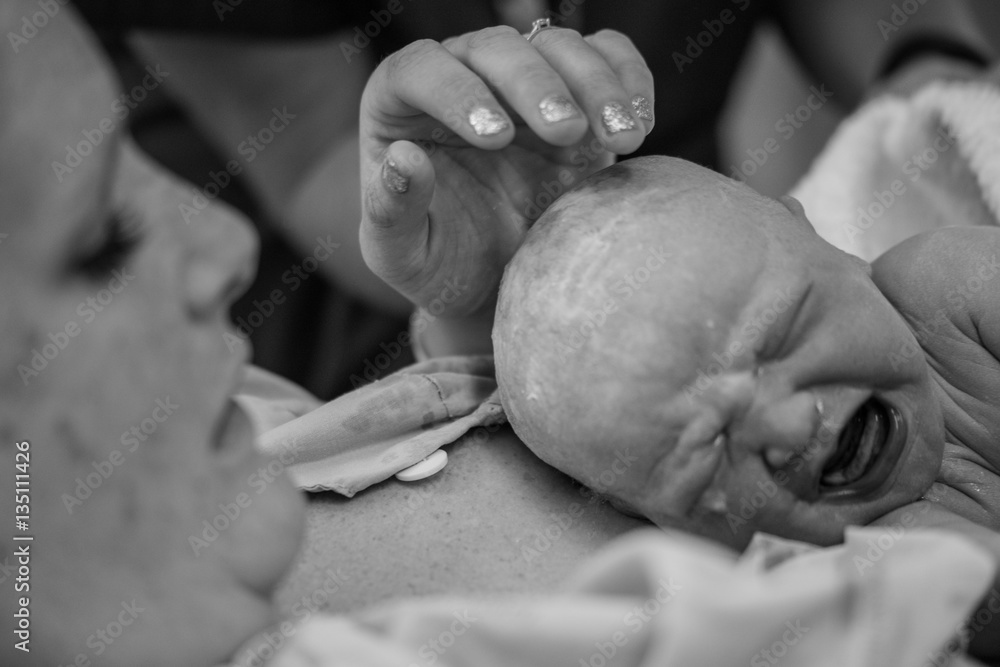 Freshly born baby skin to skin on mothers chest caucasian female ...