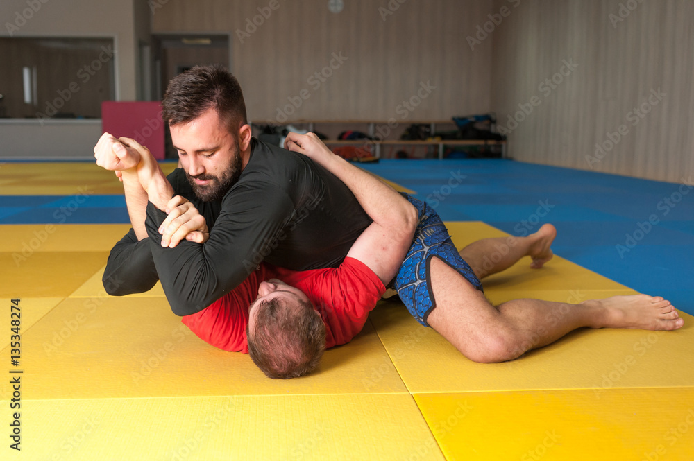 MMA fighter with beard arm locking his opponent on tatami Stock Photo ...