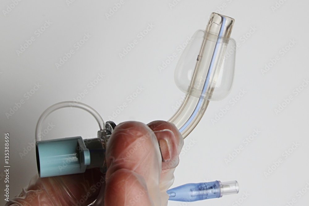 Side view of tracheostomy tube with polyurethane inflated balloon, held ...
