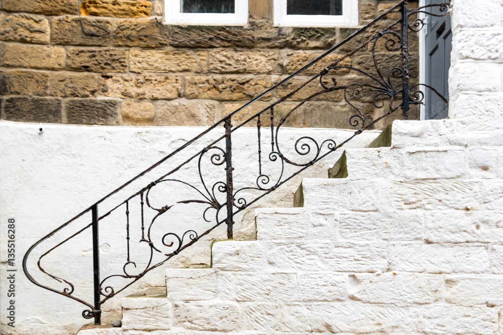 Wrought iron handrail offset against white wall and stairs Stock Photo ...