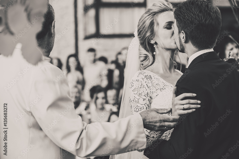 Father of a bride gives bride's hand to groom while they kiss be Stock ...