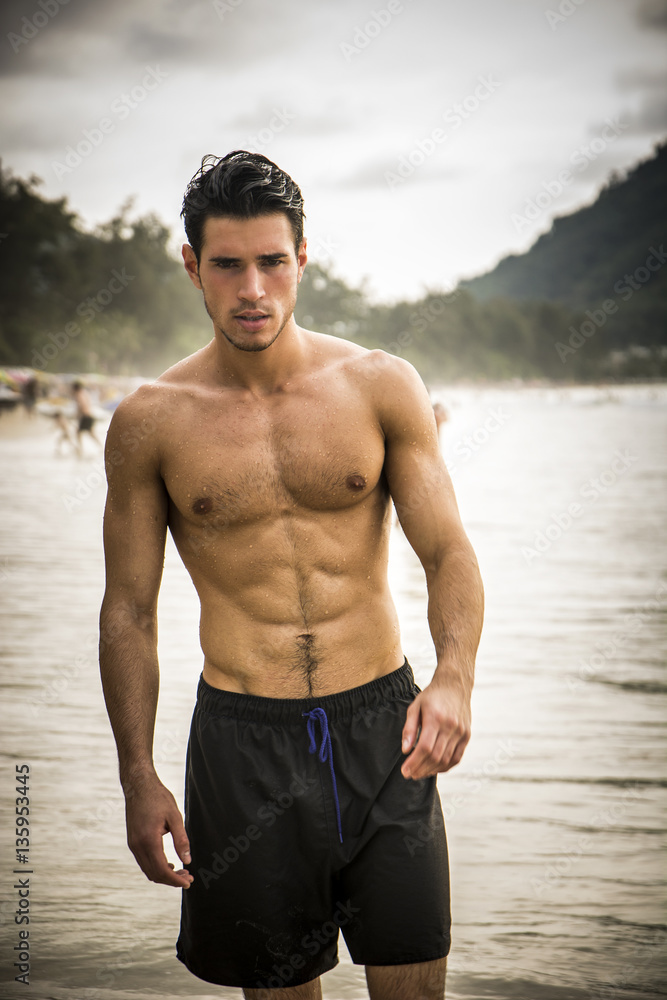 Half body shot of a handsome young man standing on a beach in Phuket ...