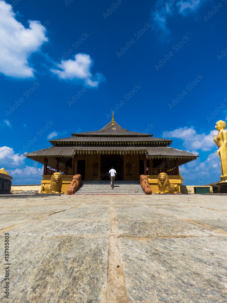 Man entering peaceful Golden Temple Palace Relic House on granite paved ...