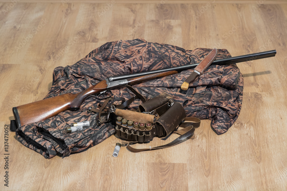 old double-barreled shotgun, camouflage jacket, knife in scabbard ...