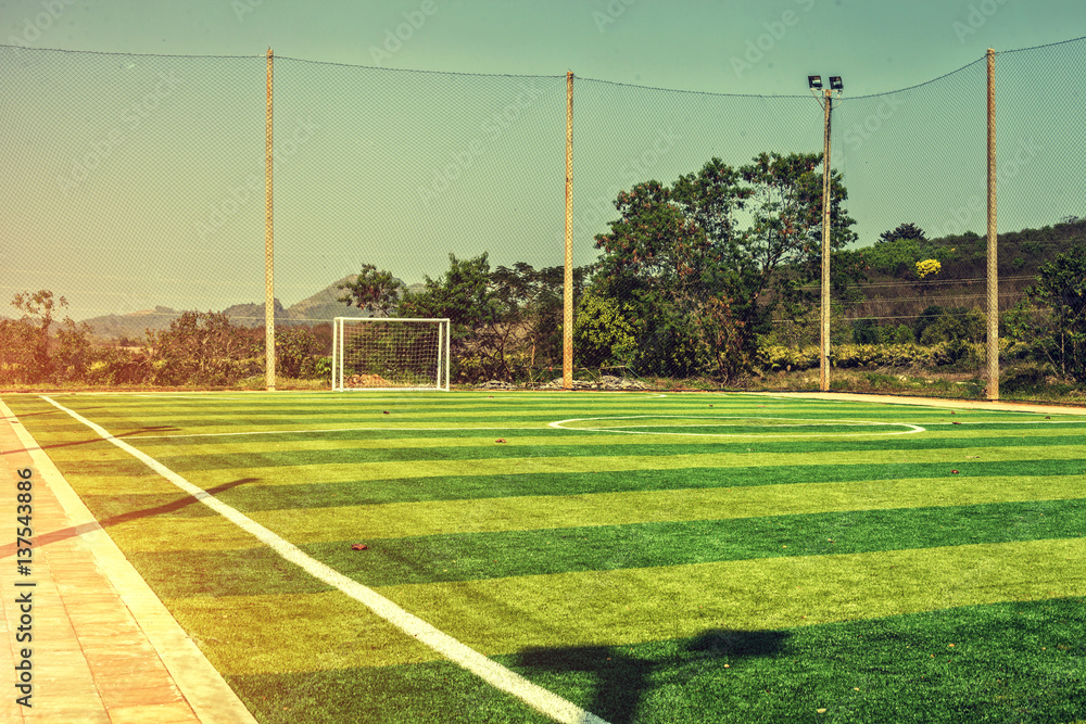 Artificial turf football field with vintage color filter and sunlight ...