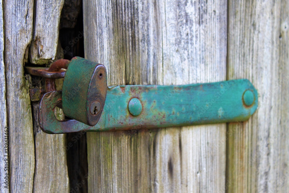 old metall padlock on a locked wooden door, no entry, shut out, bolted ...