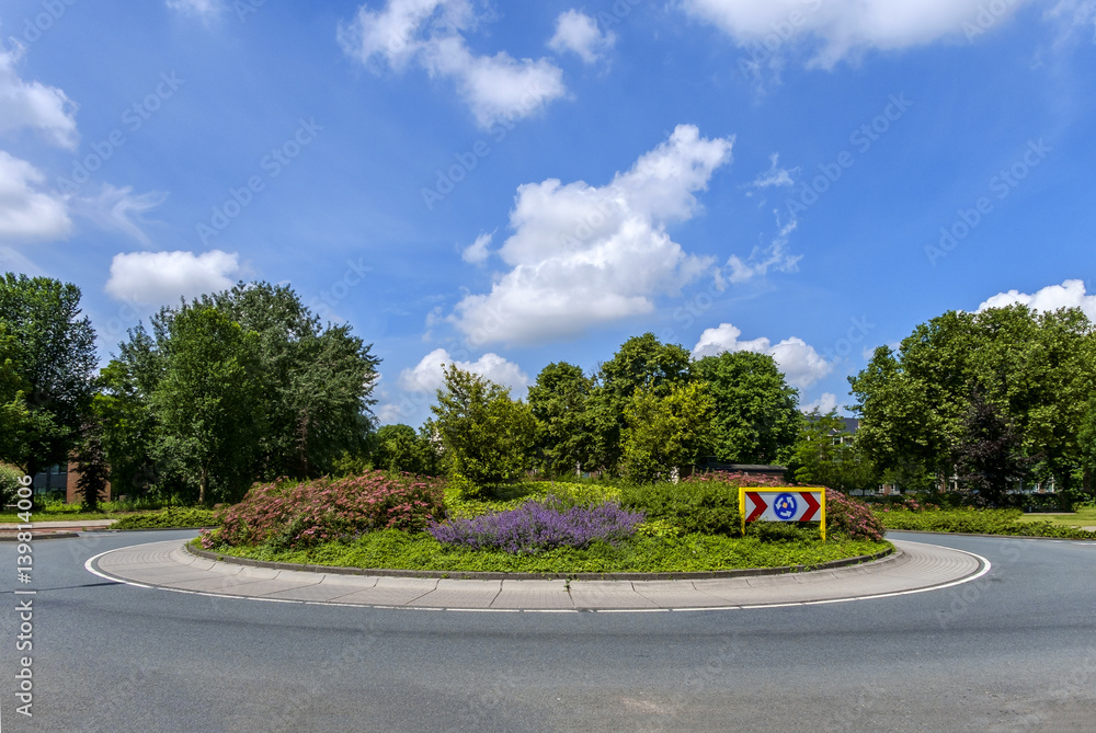 Small roundabout with plants, trees and traffic sign without any ...