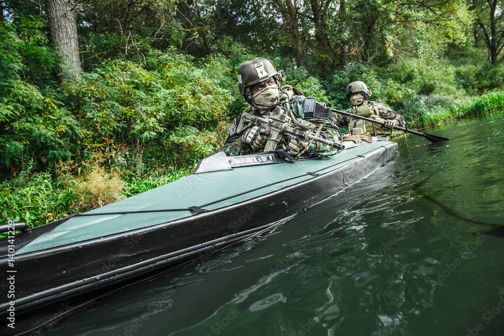Special forces men with painted faces in camouflage uniforms paddling ...