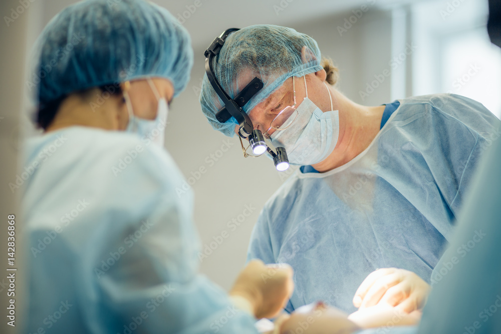 Surgeon performing cosmetic surgery on breasts in hospital operating ...