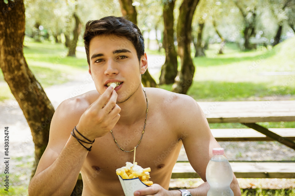 Portrait of Young Muscular Man Sitting Shirtless in Park at Picnic ...