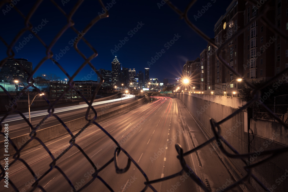 Night city skyline through the wire mesh fence Stock Photo | Adobe Stock