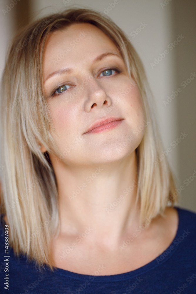 Closeup portrait of beautiful young middle age Caucasian woman in blue ...
