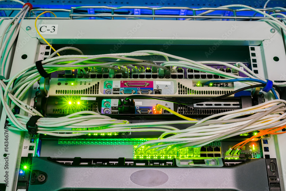 Servers and switches operating in a rack of server room Stock Photo ...