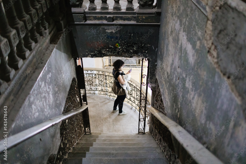 20 something uses cell phone to take photographs in a worn out building ...